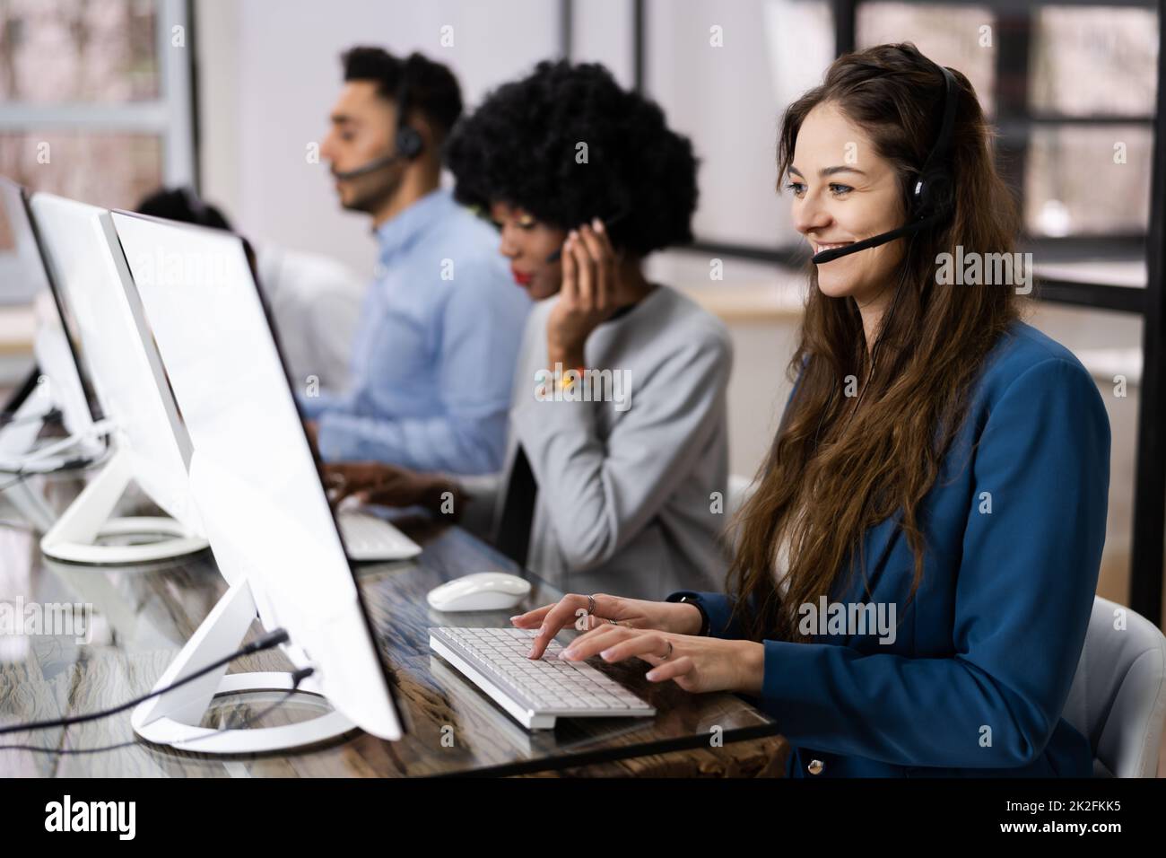 Positive Customer Services Agent With Headset Working Stock Photo - Alamy