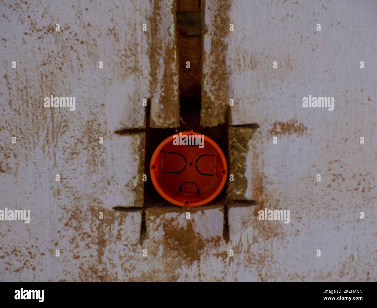 Orange round plastic backbox for socket or switch inserted into the ...