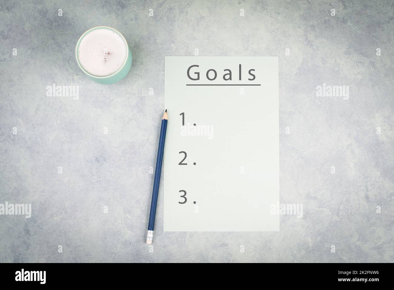 Empty paper with a pen on a textured background, the word goal is ...