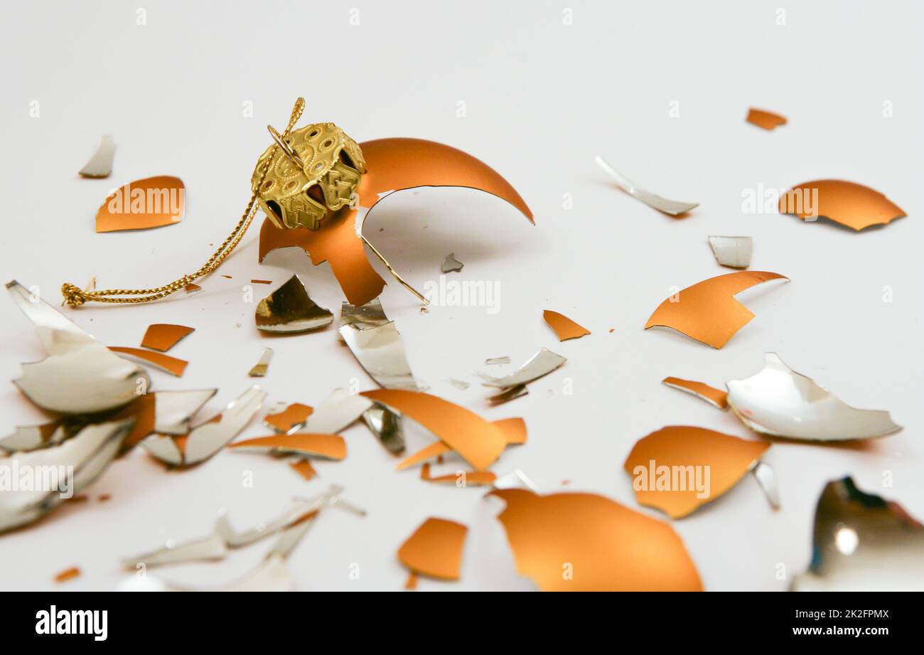 Broken golden ornament on a white background Stock Photo - Alamy