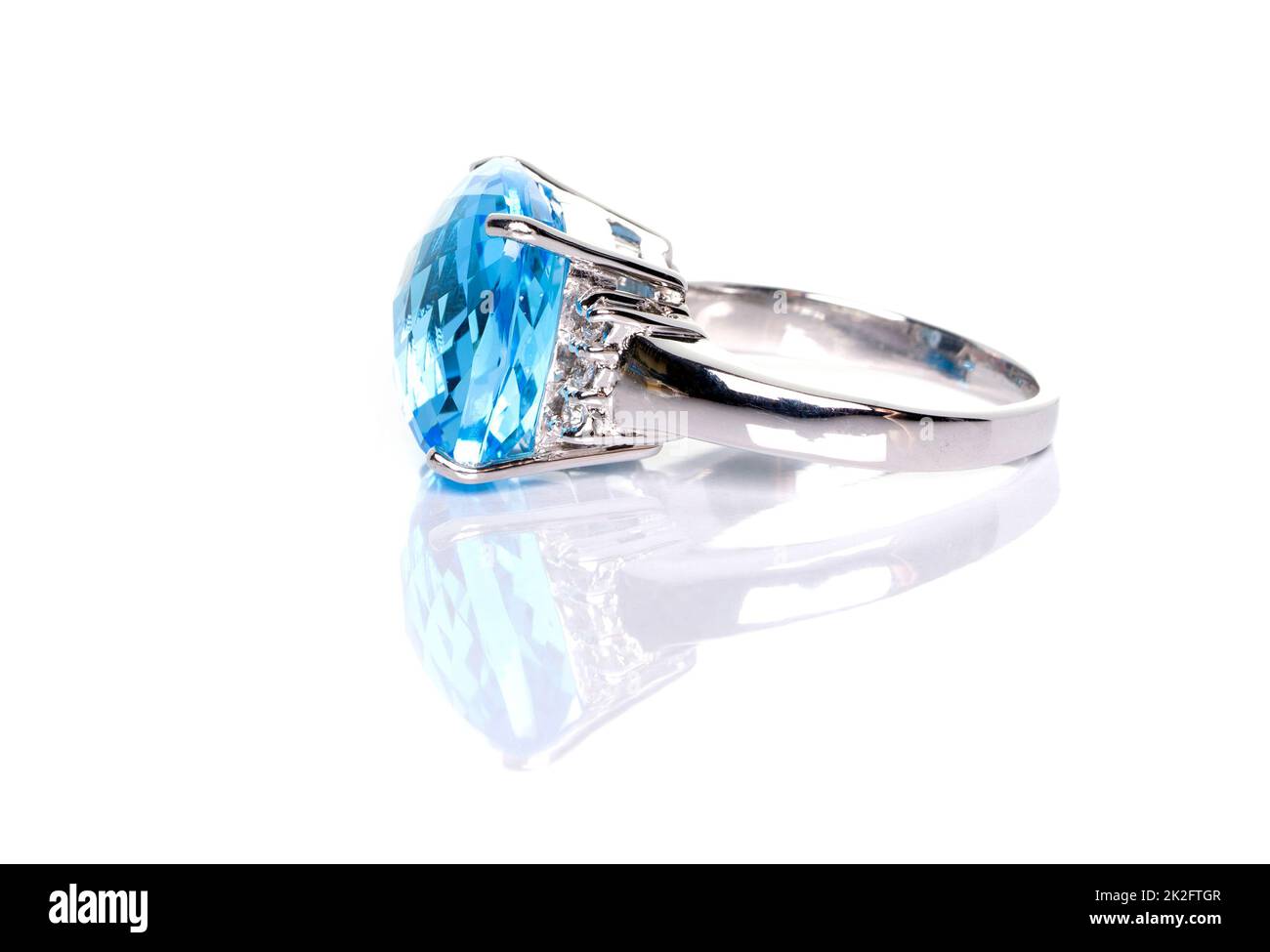 Cushion cut blue topaz ring on white background with reflection. Collection of natural gemstones ...