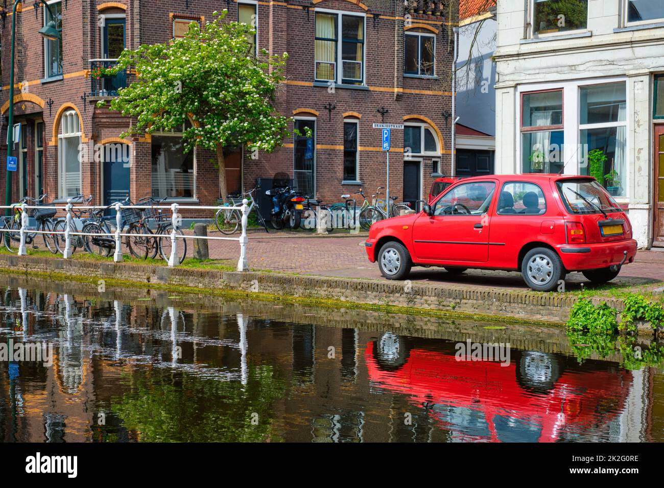 Cars on canal embankment in street of Delft. Delft, Netherlands Stock ...