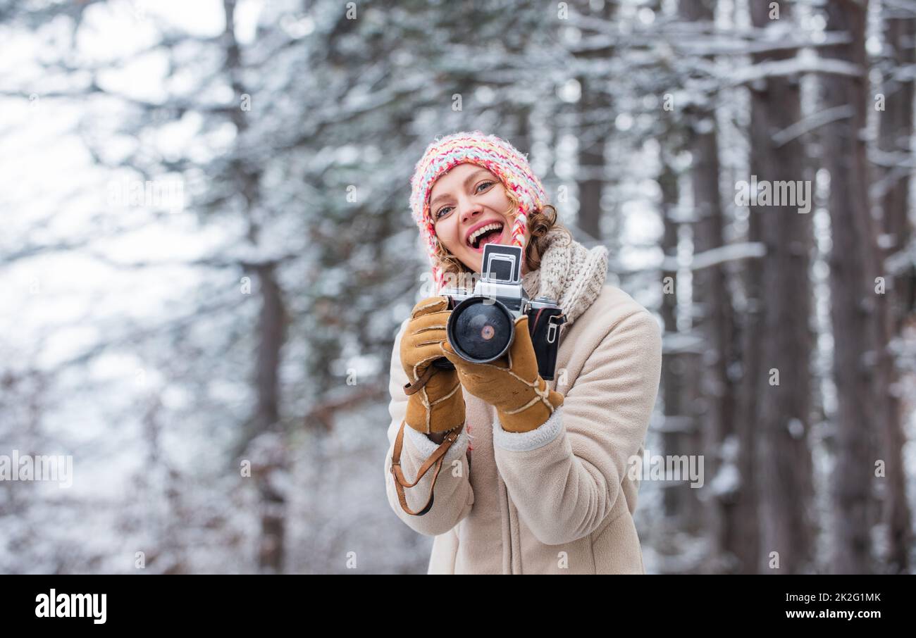 Spend day outdoors. Girl with vintage camera in snowy nature. Traveling ...