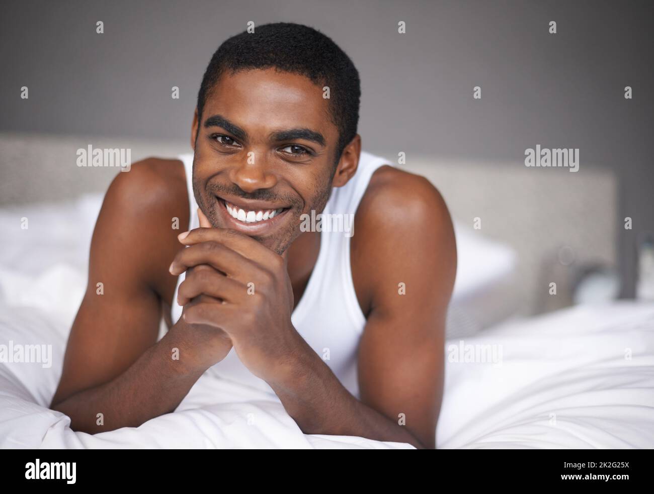 Nothing better than the comfort of a bed. Portrait of a handsome young ...