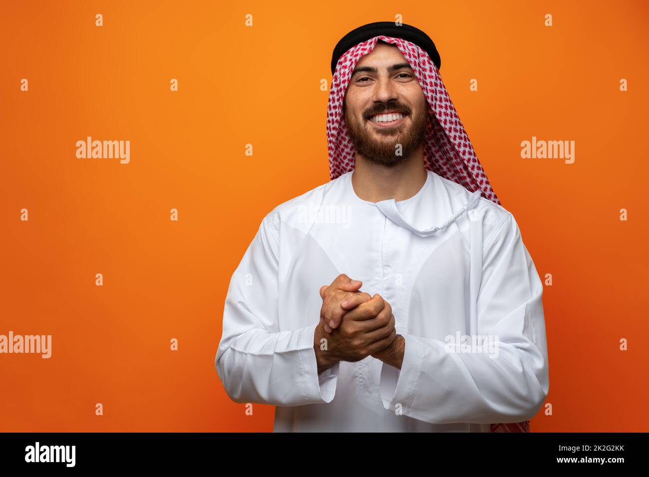 Portrait of young smiling Arab man on orange background Stock Photo - Alamy
