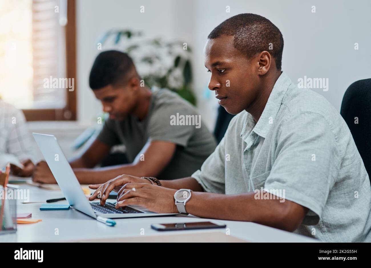 Getting right down to it. Shot of a young businessman using a computer ...