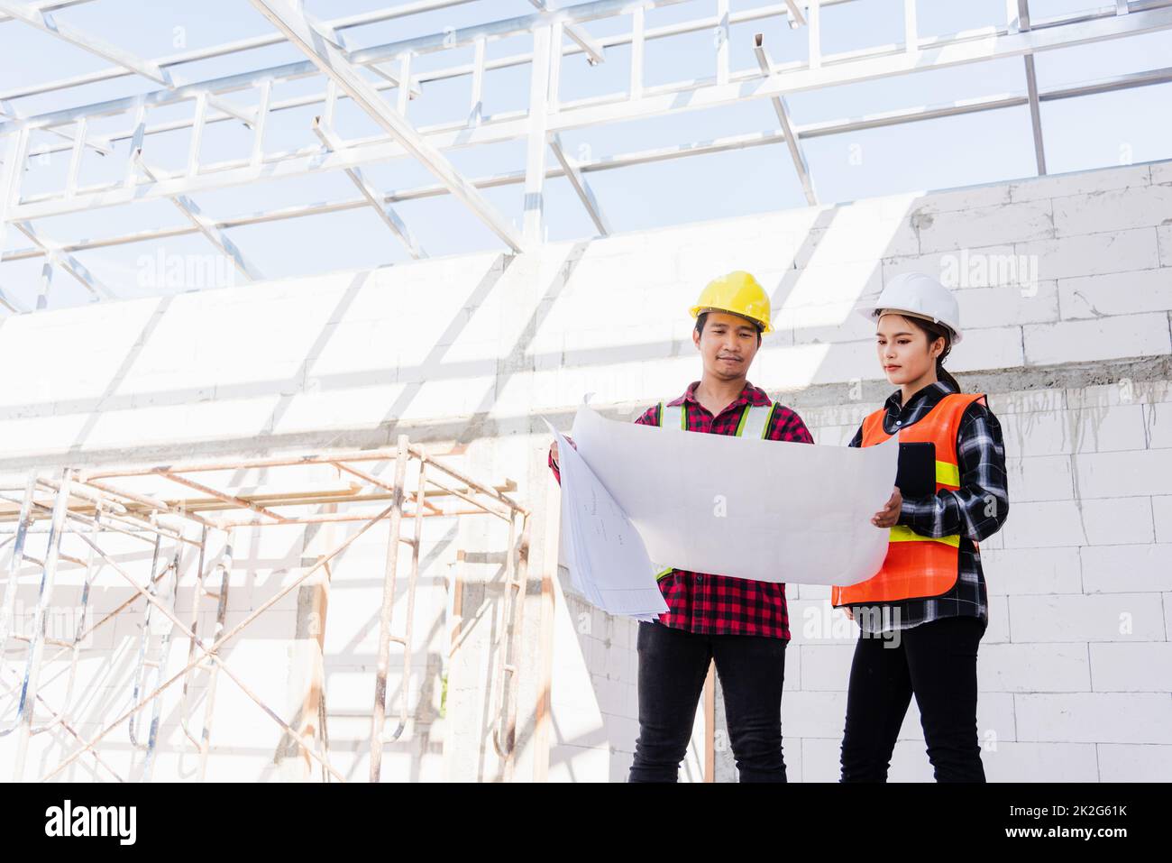 Architect and client discussing the plan with blueprint of the building ...