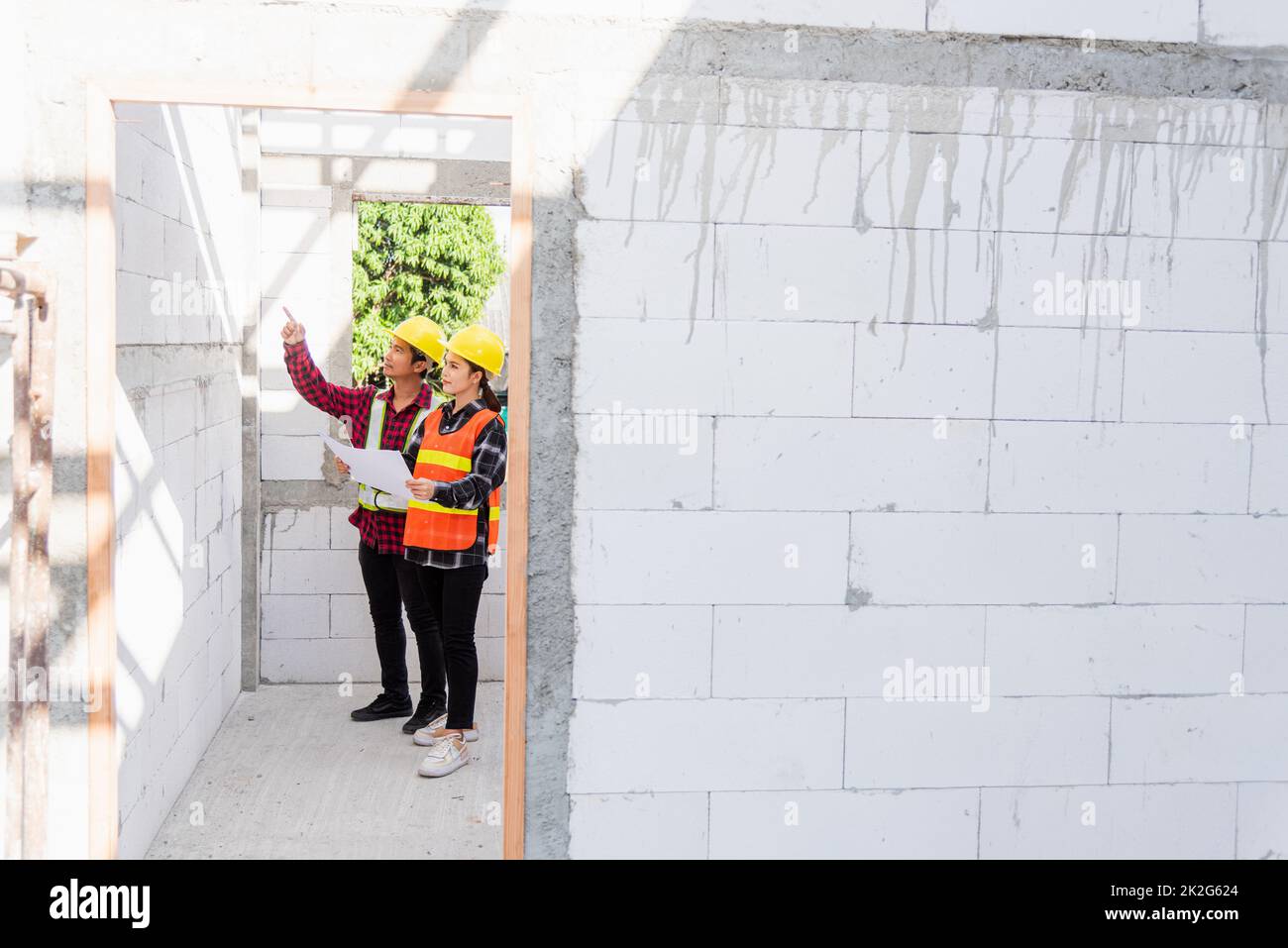 Architect and client discussing the plan with blueprint of the building ...