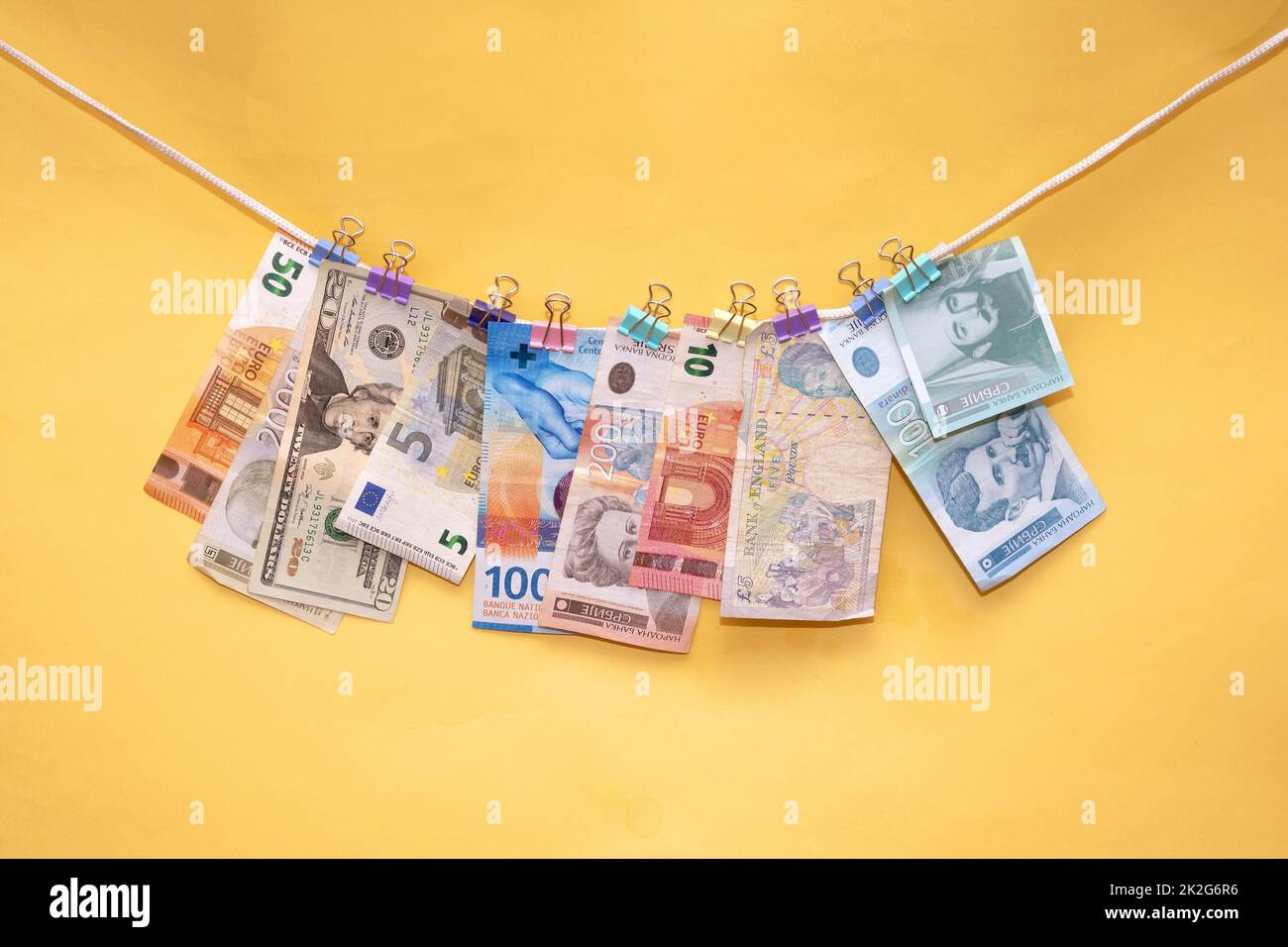 Different currencies banknotes hanging on a string Stock Photo - Alamy