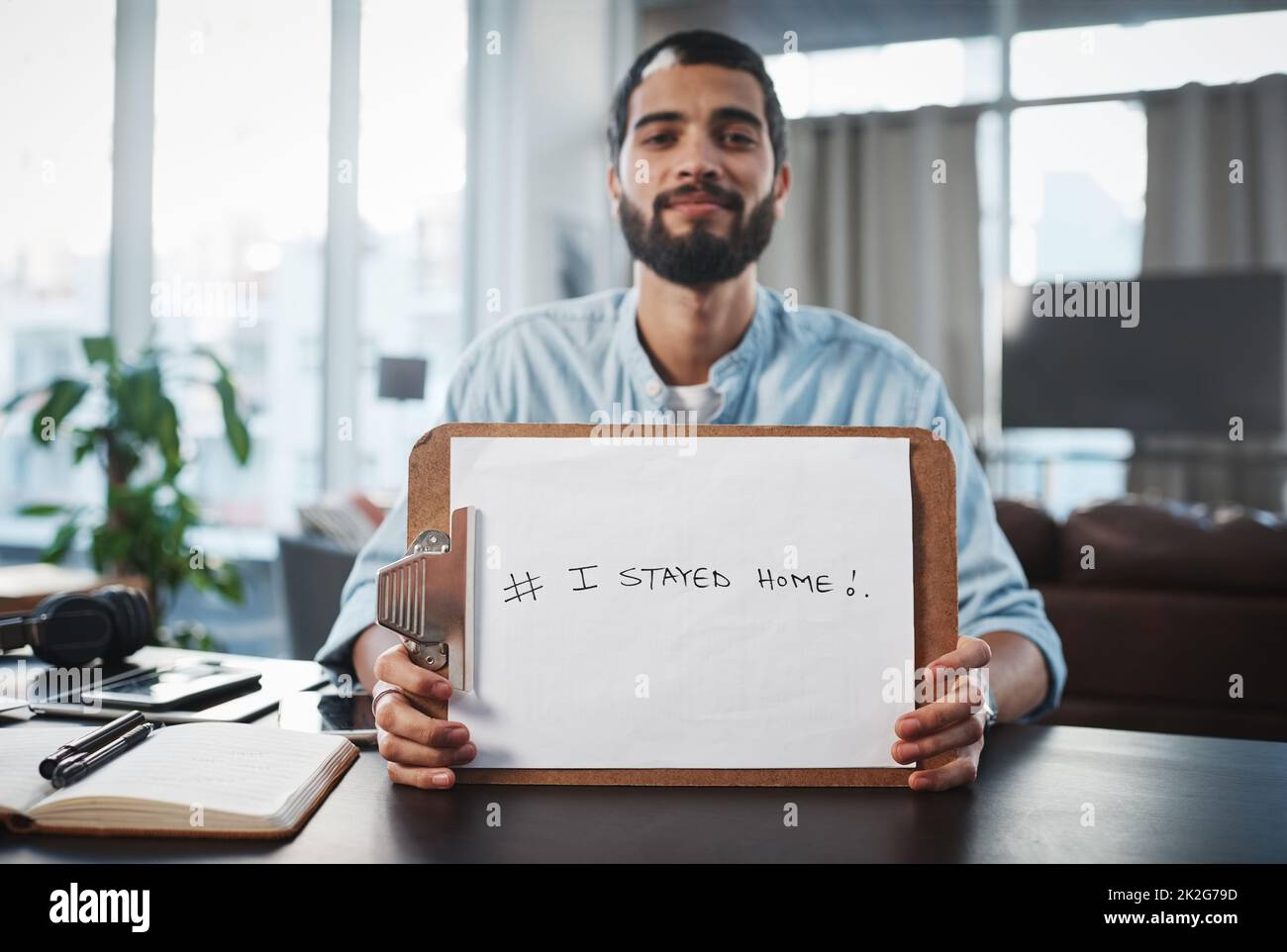 I made a difference by staying home. Shot of a young man holding up a ...
