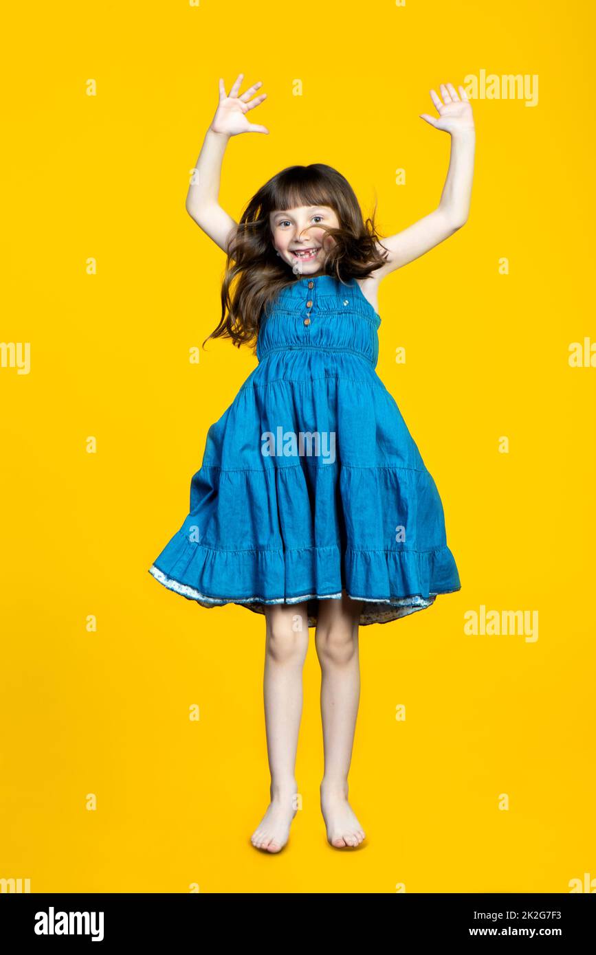 Funny preschooler girl joyfully jumps and smiles. The child is happy ...