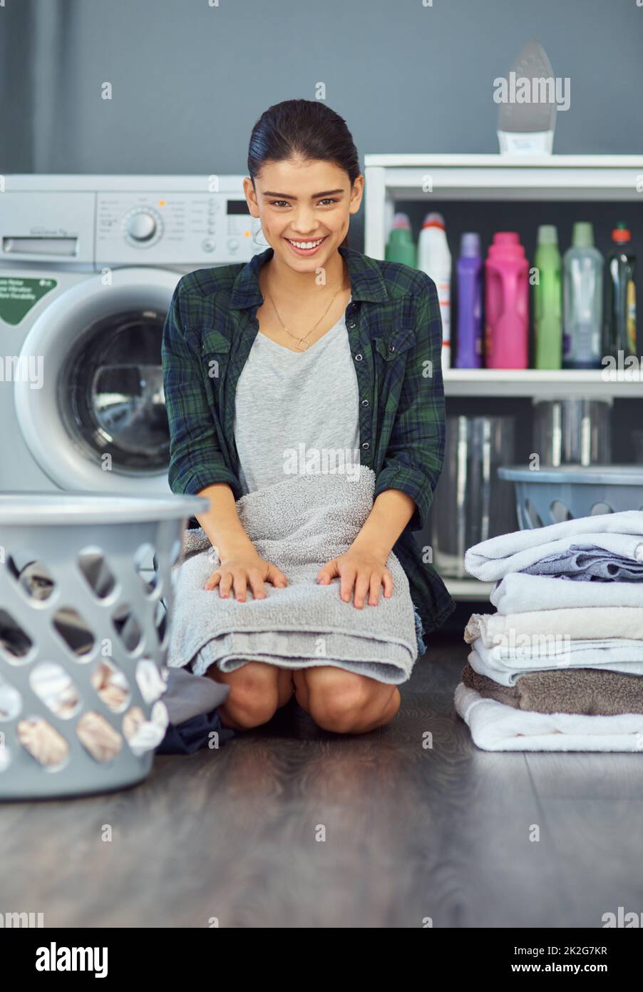 I always fold my washing immediately. Full length portrait of an attractive young woman folding ...