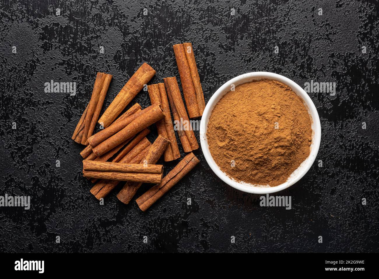 Dry cinnamon sticks and cinnamon powder on black table. Cinnamon spice ...
