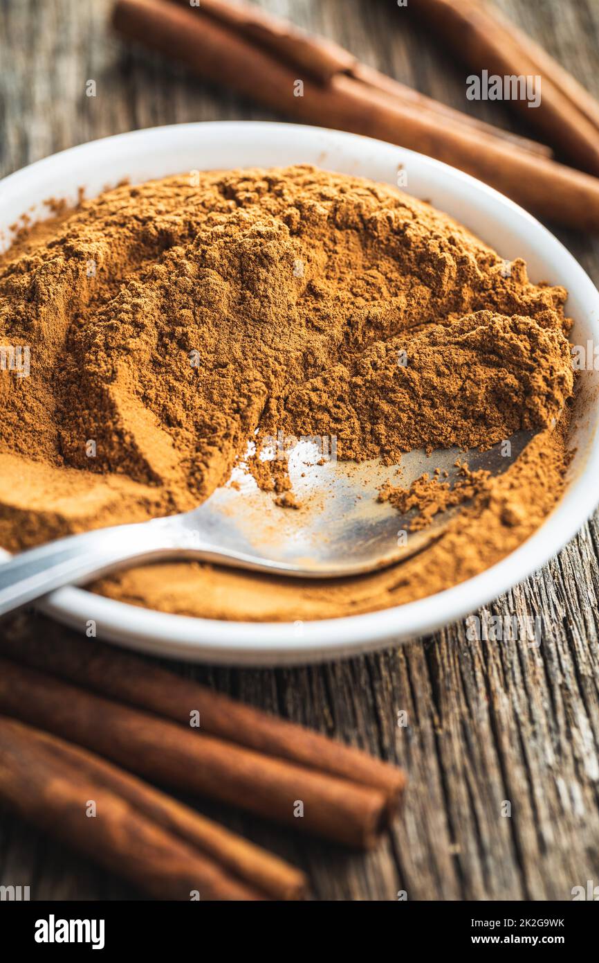 Dry cinnamon sticks and cinnamon powder on wooden table. Cinnamon spice ...