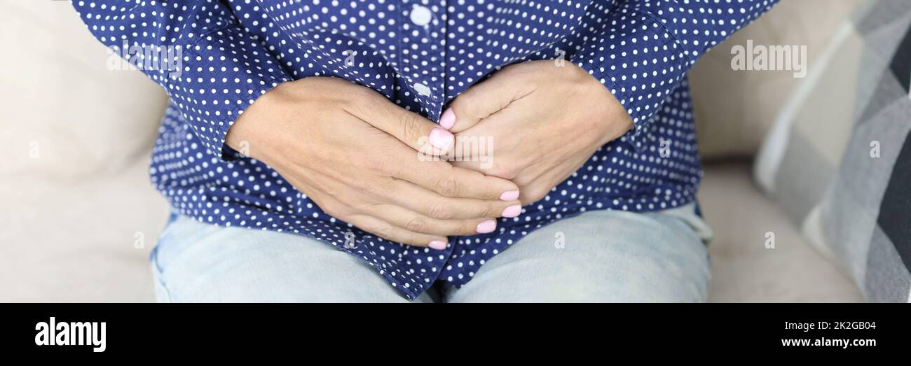 Women hands on stomach with painful spasms closeup Stock Photo - Alamy