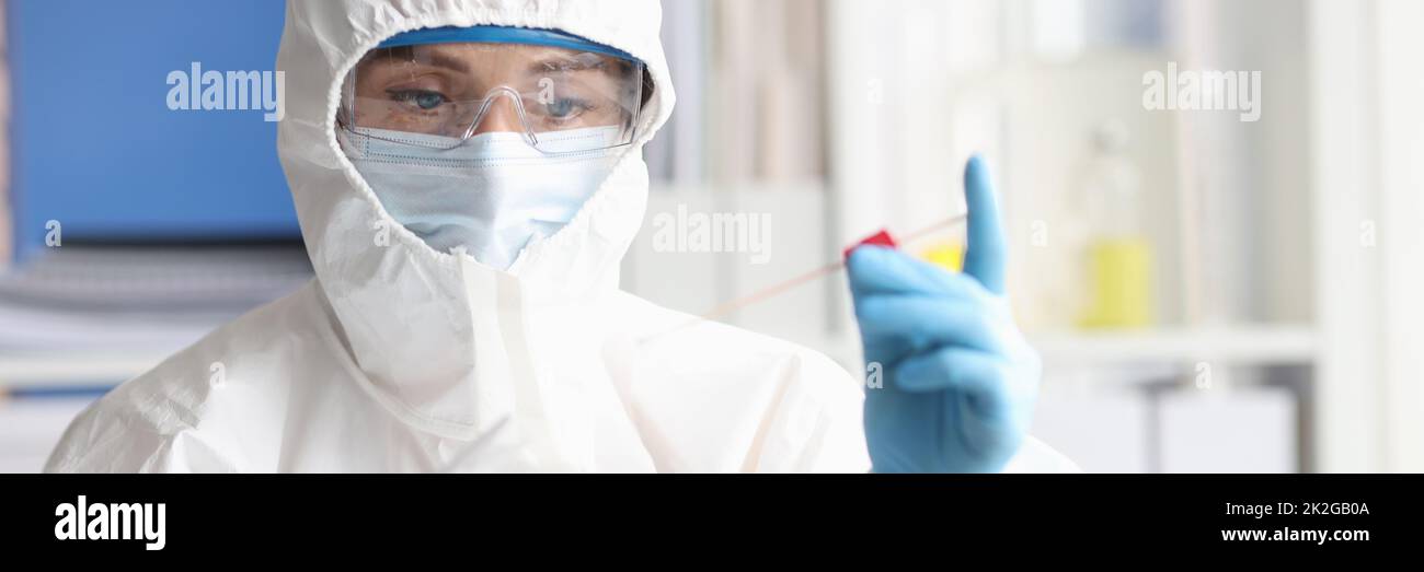 Scientist in protective suit and goggles conducts research in ...