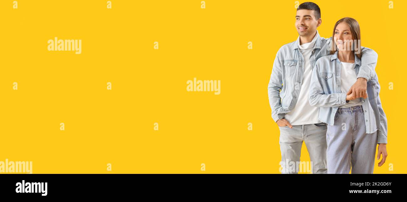Stylish happy young couple in jeans clothes on yellow background with ...