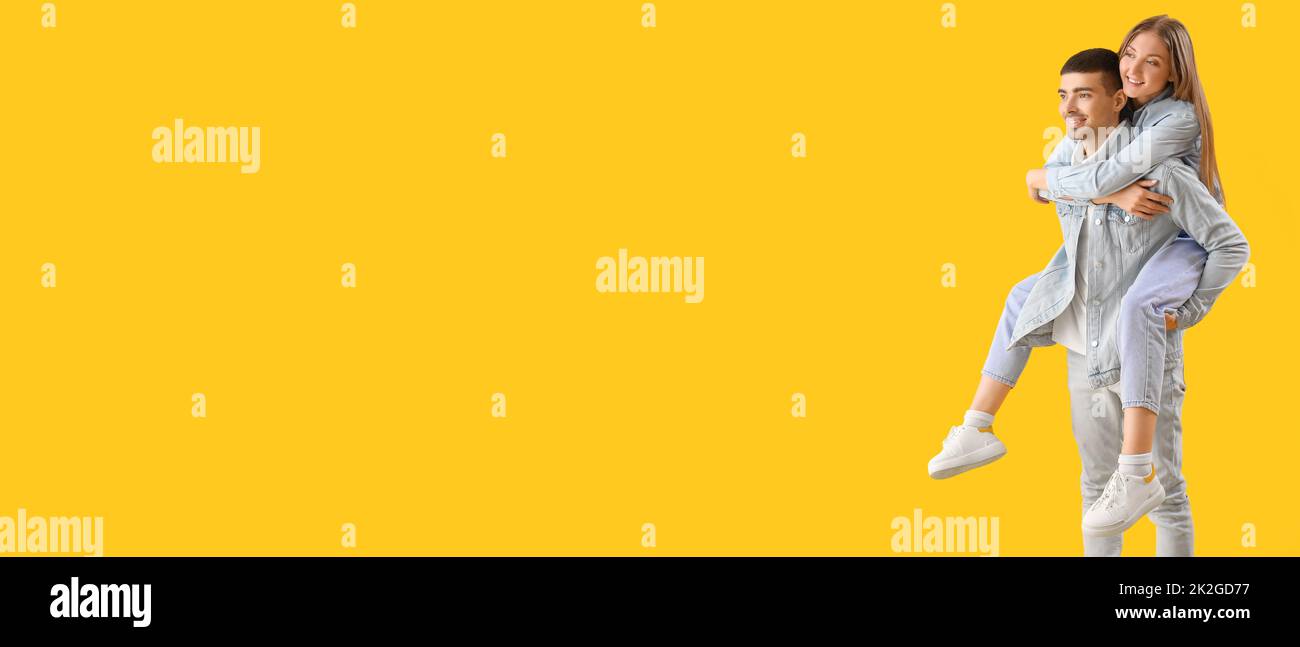 Stylish happy young couple in jeans clothes on yellow background with ...