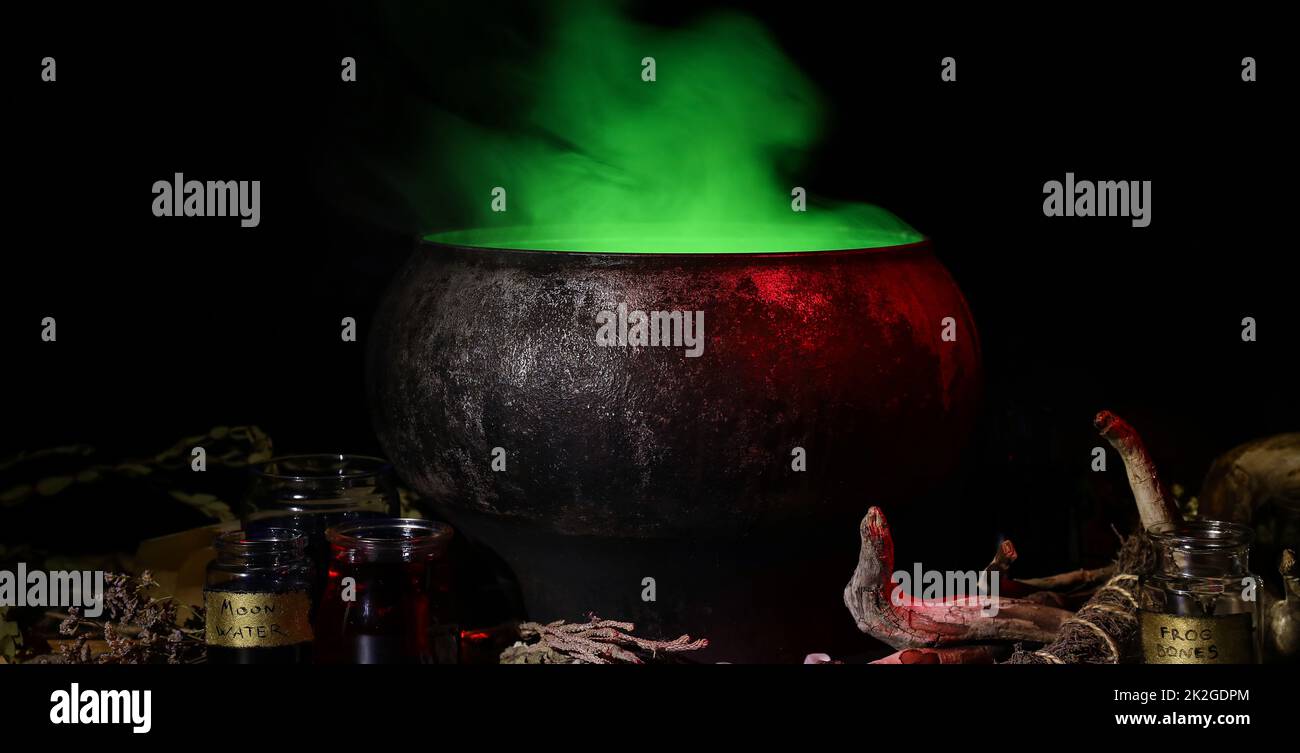 Witch's cauldron with potion and magic attributes for ritual on dark ...