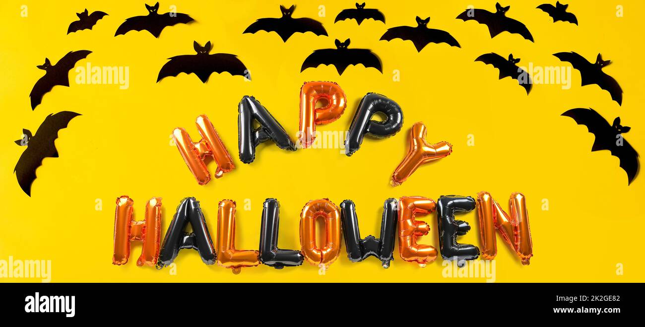 Text HAPPY HALLOWEEN made of balloons and paper bats on yellow ...