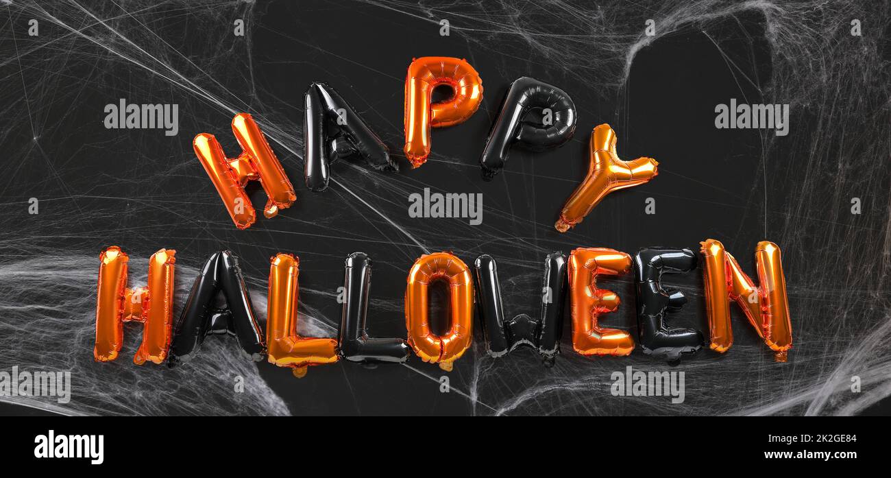 Text HAPPY HALLOWEEN made of balloons and spiderweb on black background ...