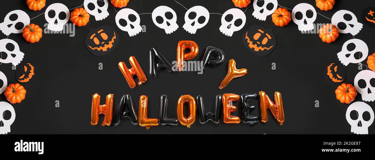Text HAPPY HALLOWEEN made of balloons, pumpkins and paper garland on ...