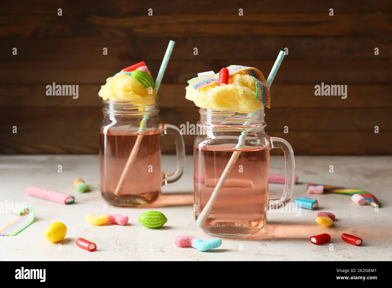 Mason jars with tasty cotton candy cocktail and sweets on table Stock ...