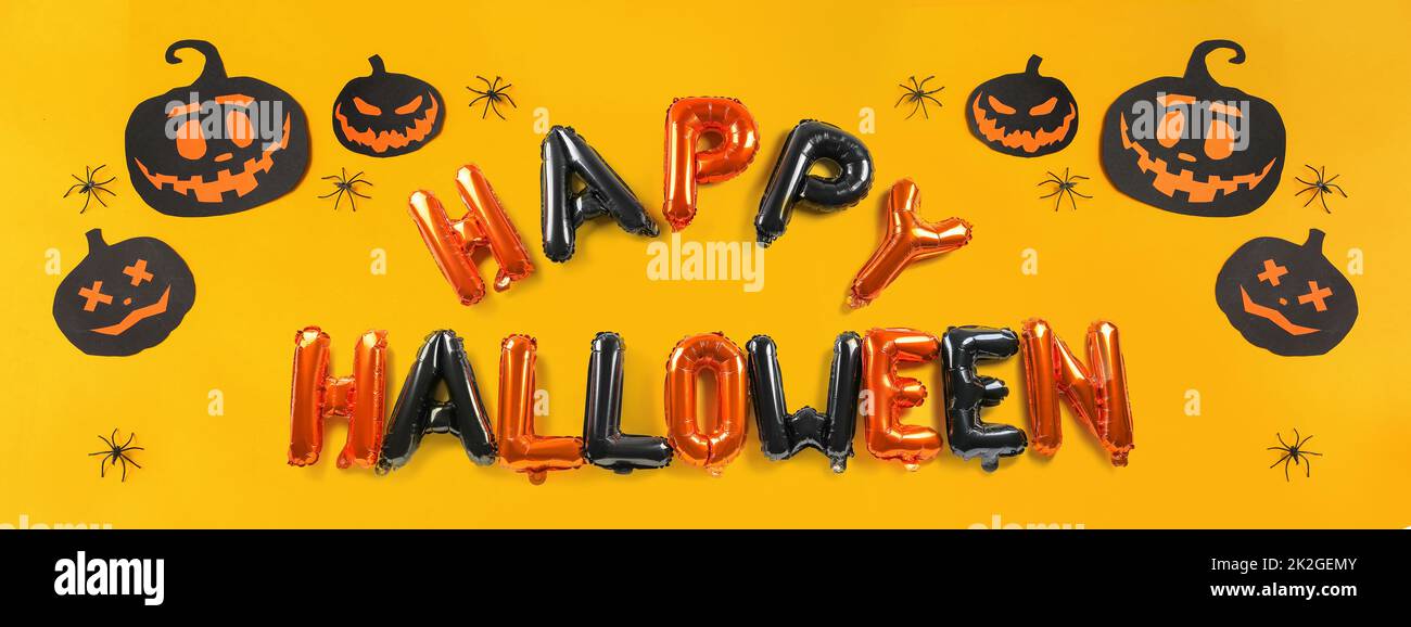 Text HAPPY HALLOWEEN made of balloons and paper pumpkins on yellow ...