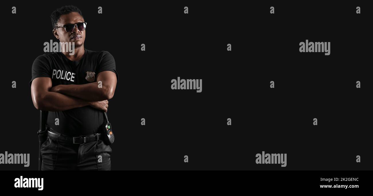 African-American police officer on dark background with space for text ...