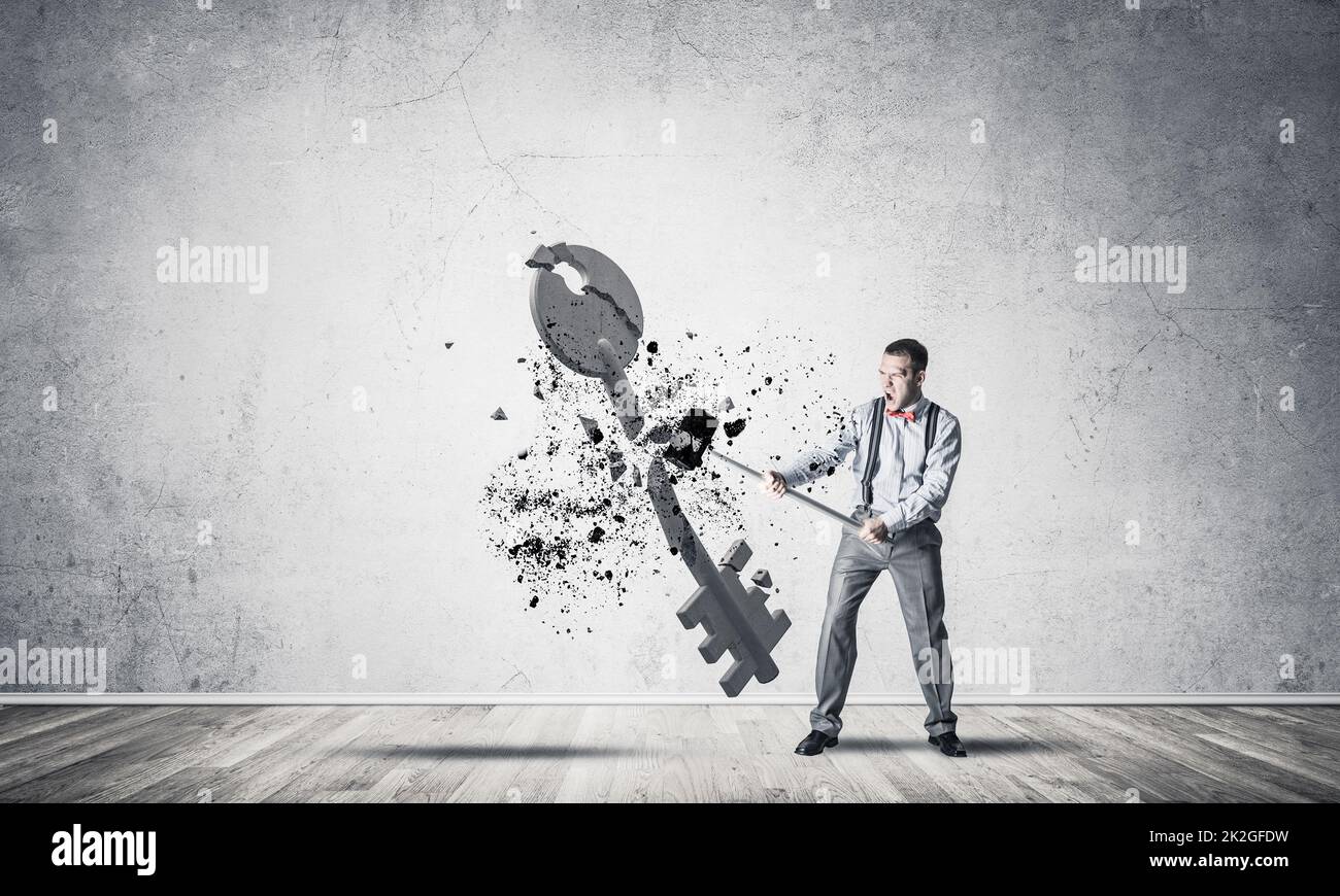 Breaking through access concept with man in room crashing concrete key ...
