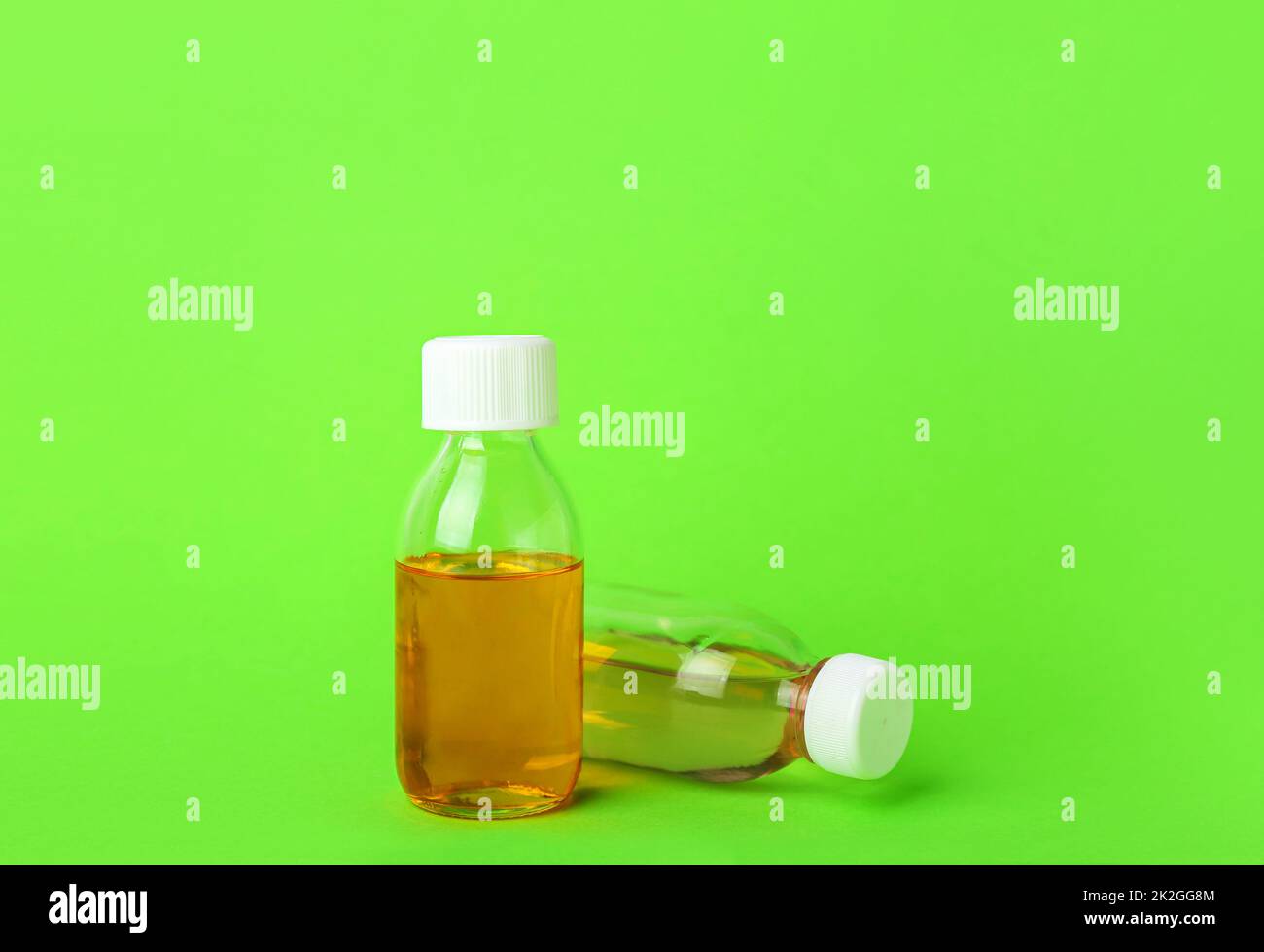 Bottles of cough syrup on green background Stock Photo - Alamy