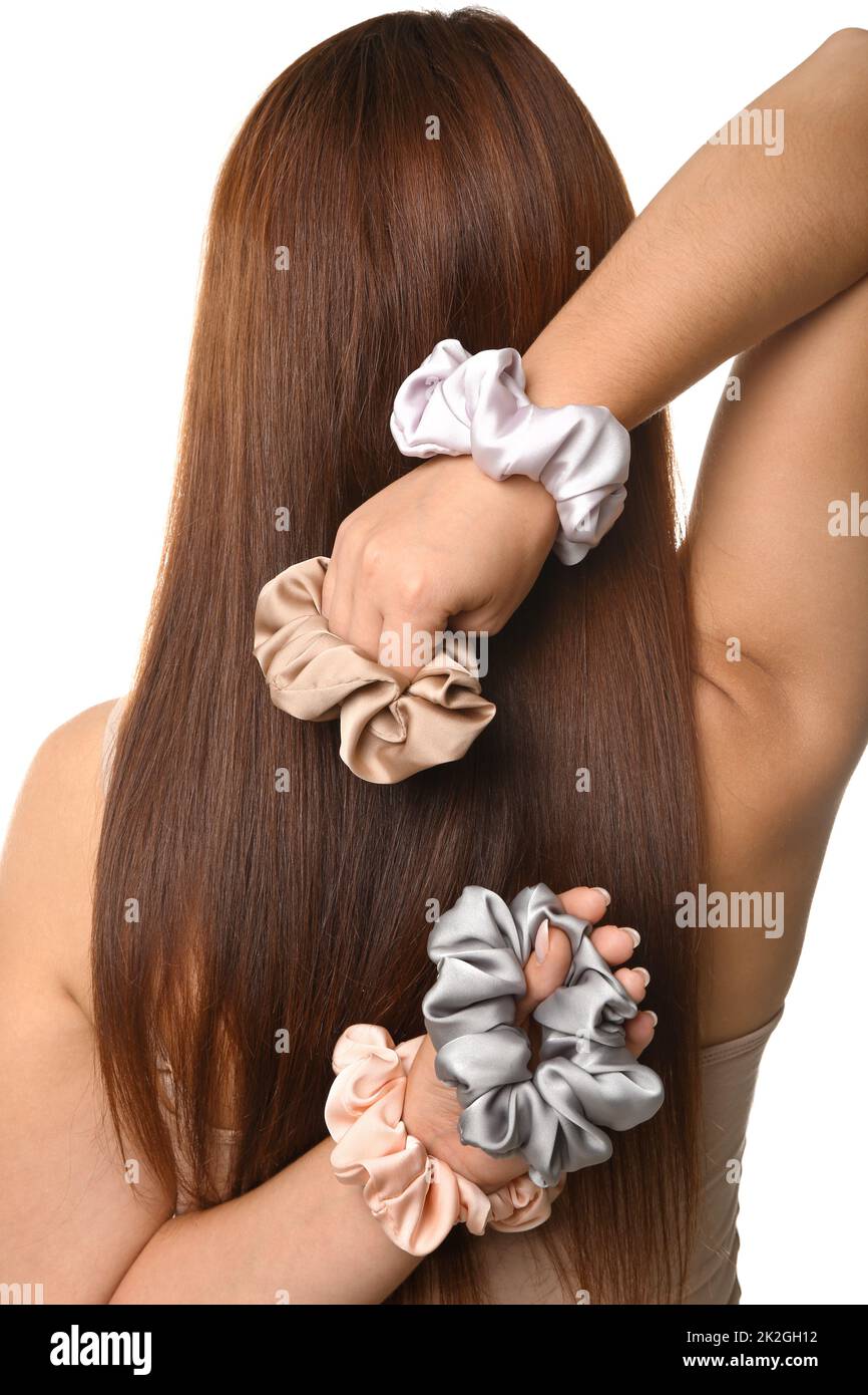 Woman with long hair holding different scrunchies on white background ...