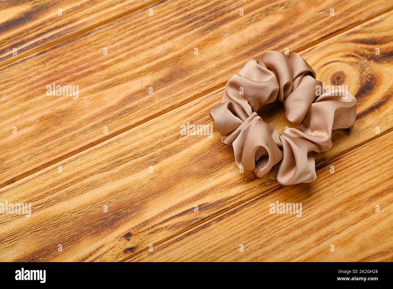 Silk scrunchy on wooden background Stock Photo - Alamy