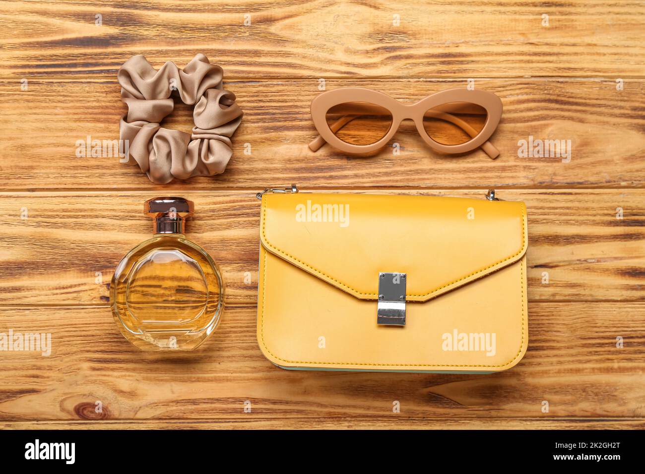 Perfume bottle, sunglasses, bag and silk scrunchy on wooden background ...