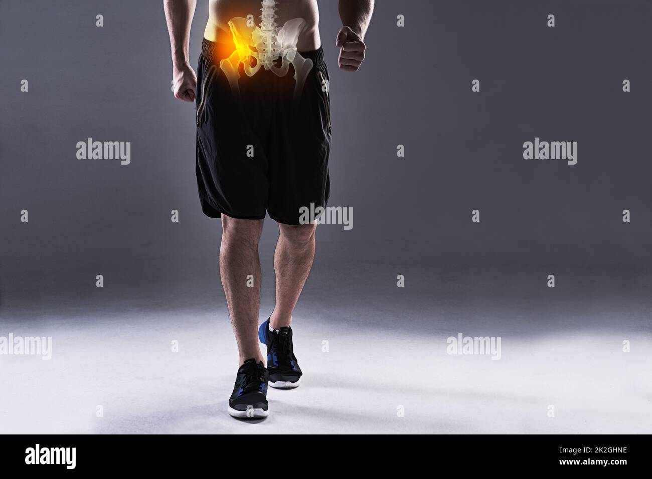 Carrying a hip injury. Cropped shot of a young man in the studio with ...