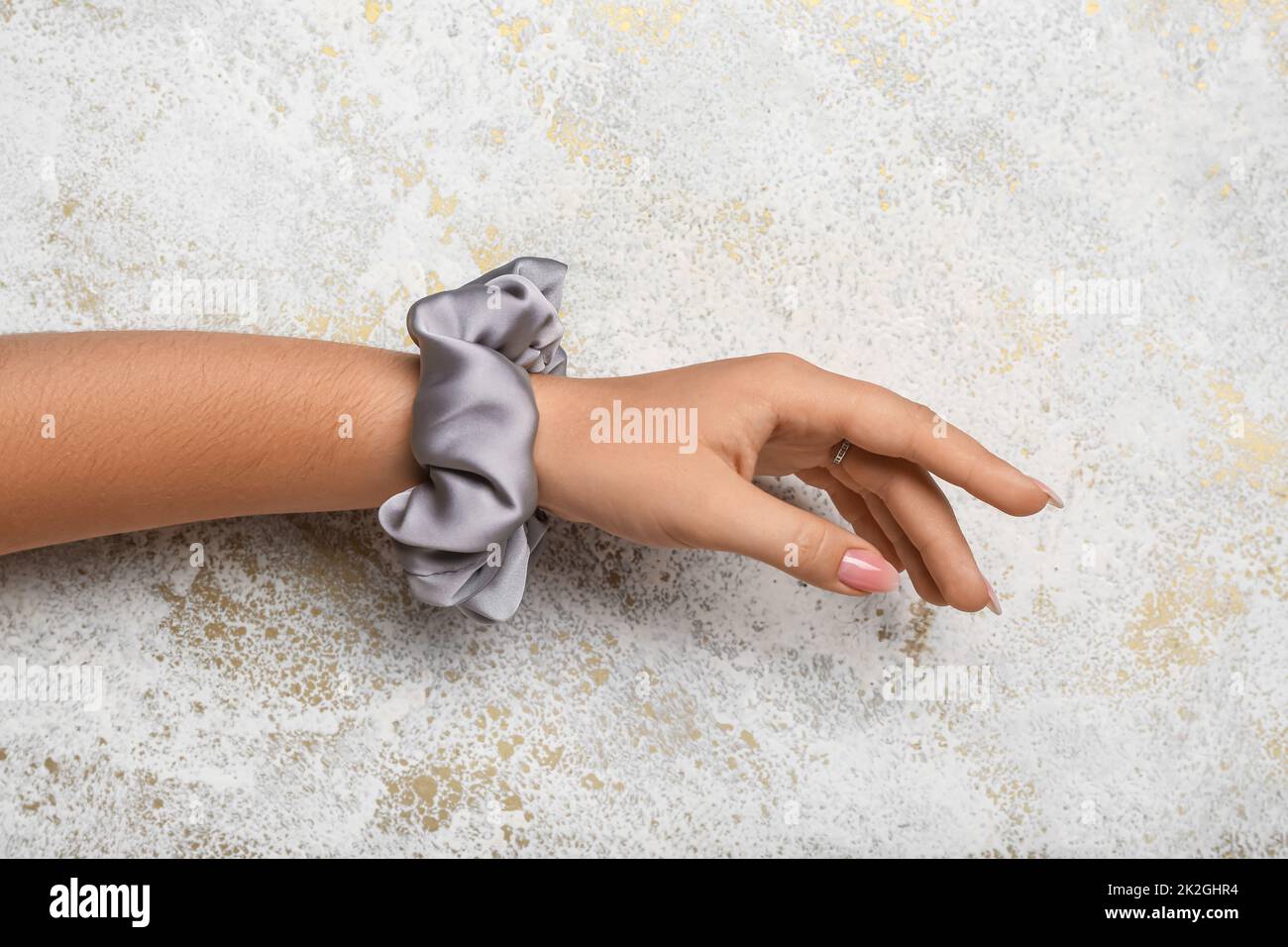 Female hand with silk scrunchy on light background Stock Photo - Alamy