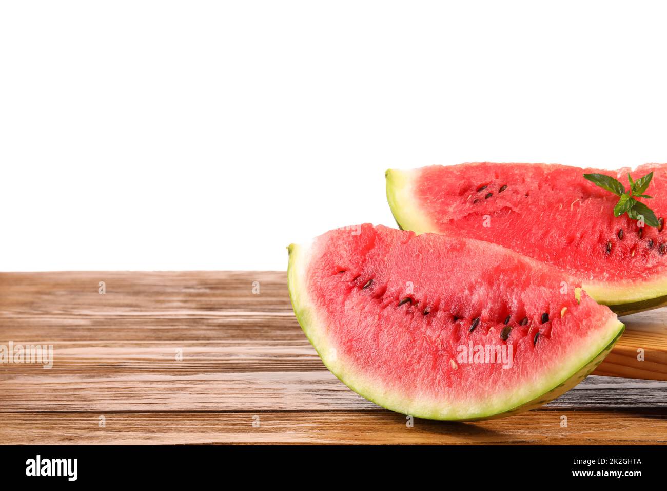 Stand with slices of ripe watermelon and mint on table against white ...
