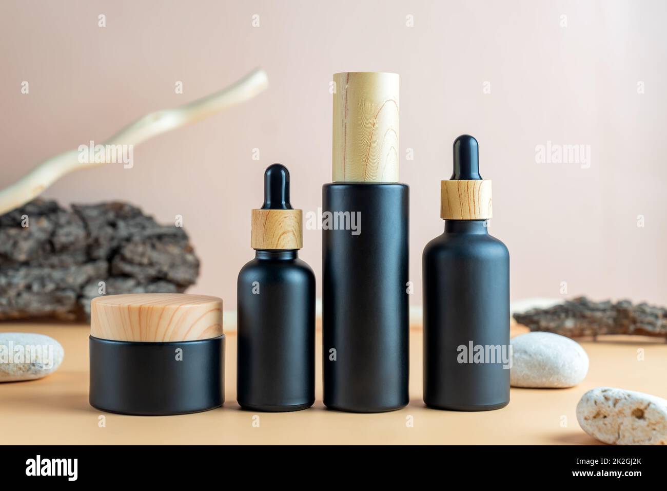 Set of natural cosmetics in black frosted glass packages on on beige ...