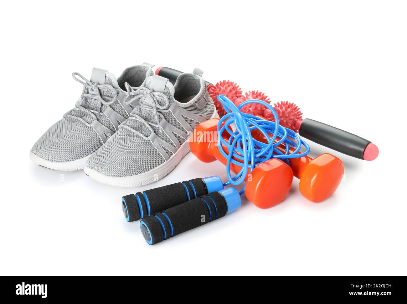 Skipping rope, body roller, dumbbells and sneakers on white background ...