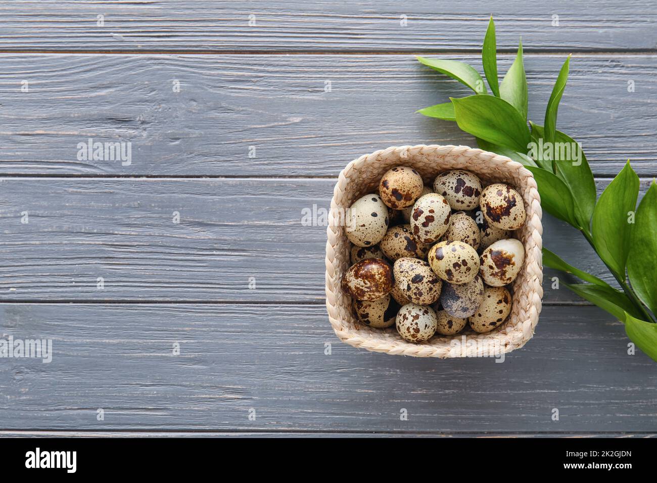Wicker basket with quail eggs on dark wooden background Stock Photo - Alamy