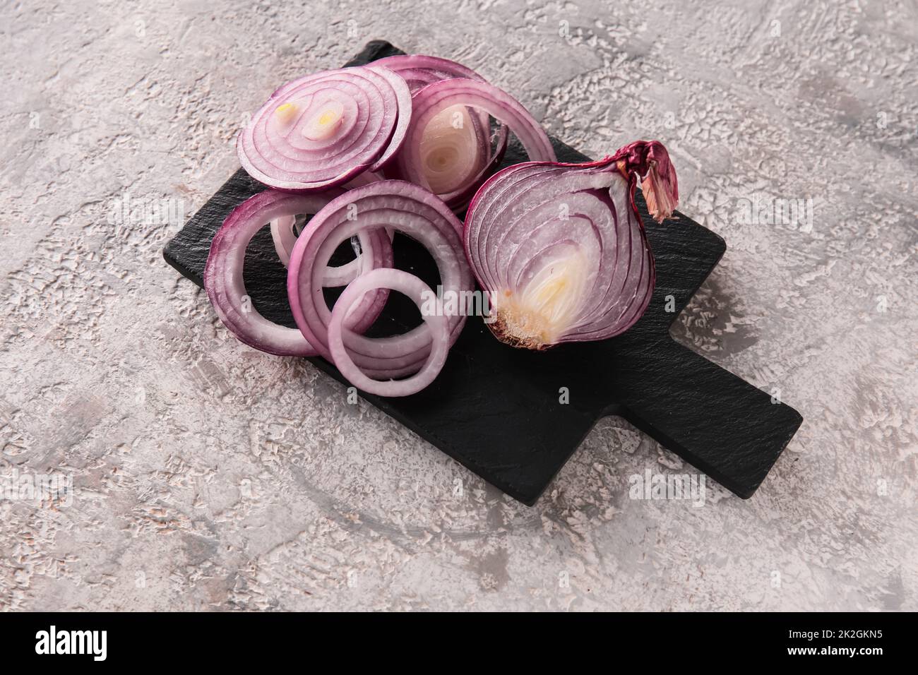 Board with cut red onion on light background Stock Photo - Alamy
