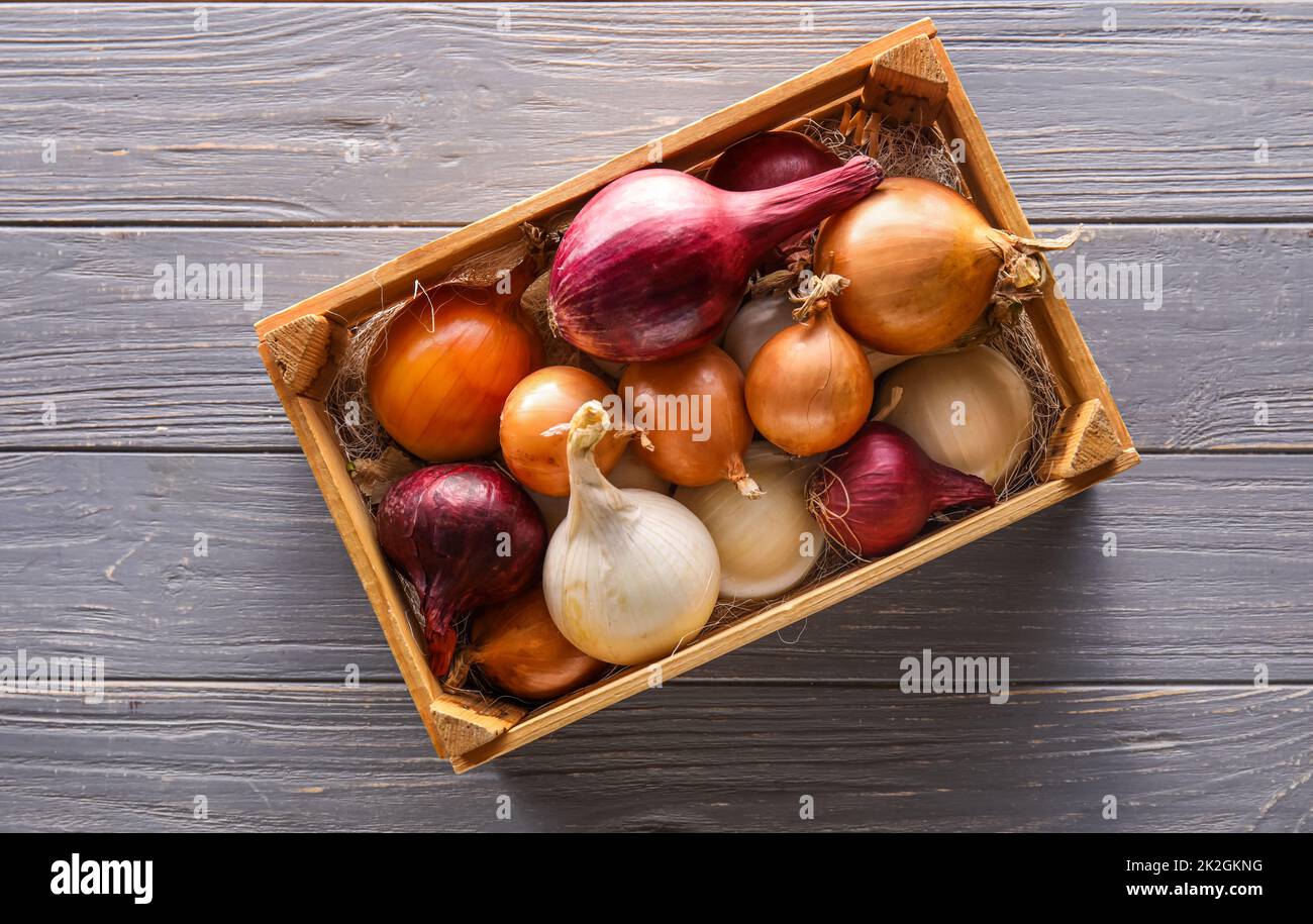 Box with different kinds of onion on dark wooden background Stock Photo ...