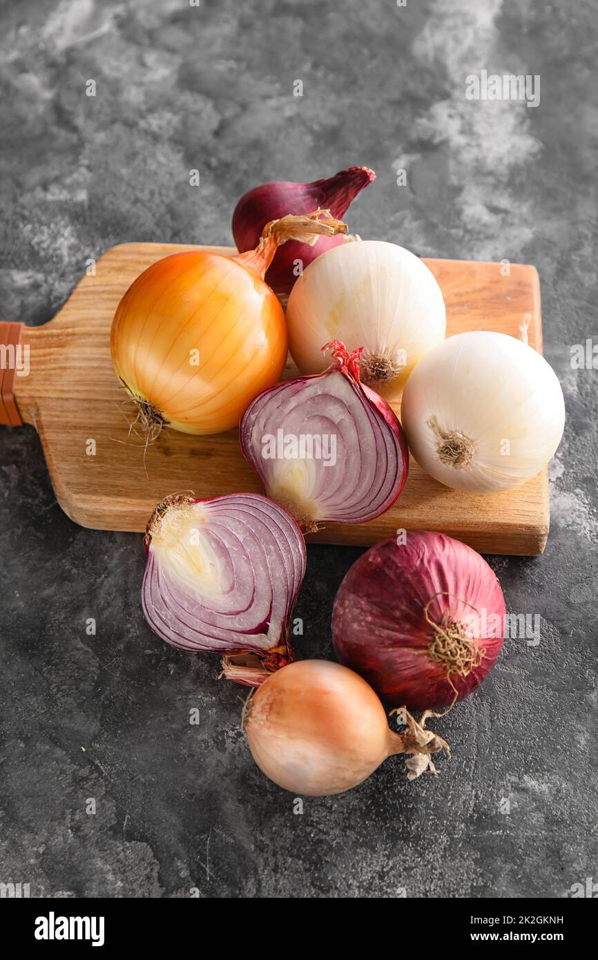 Wooden board with onion on grunge background, closeup Stock Photo - Alamy