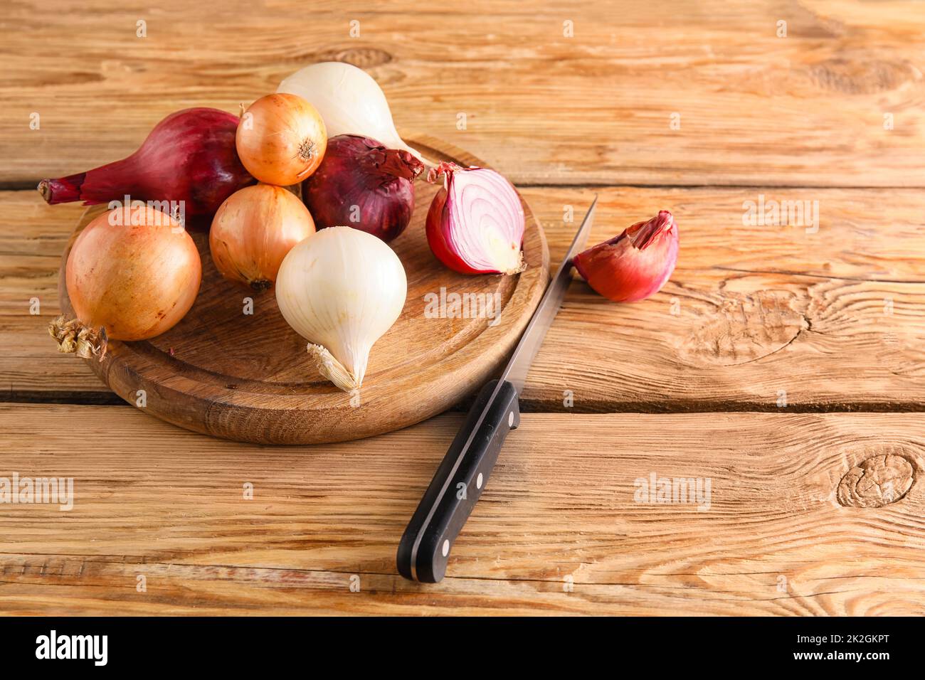 Board with fresh onion on wooden background Stock Photo - Alamy