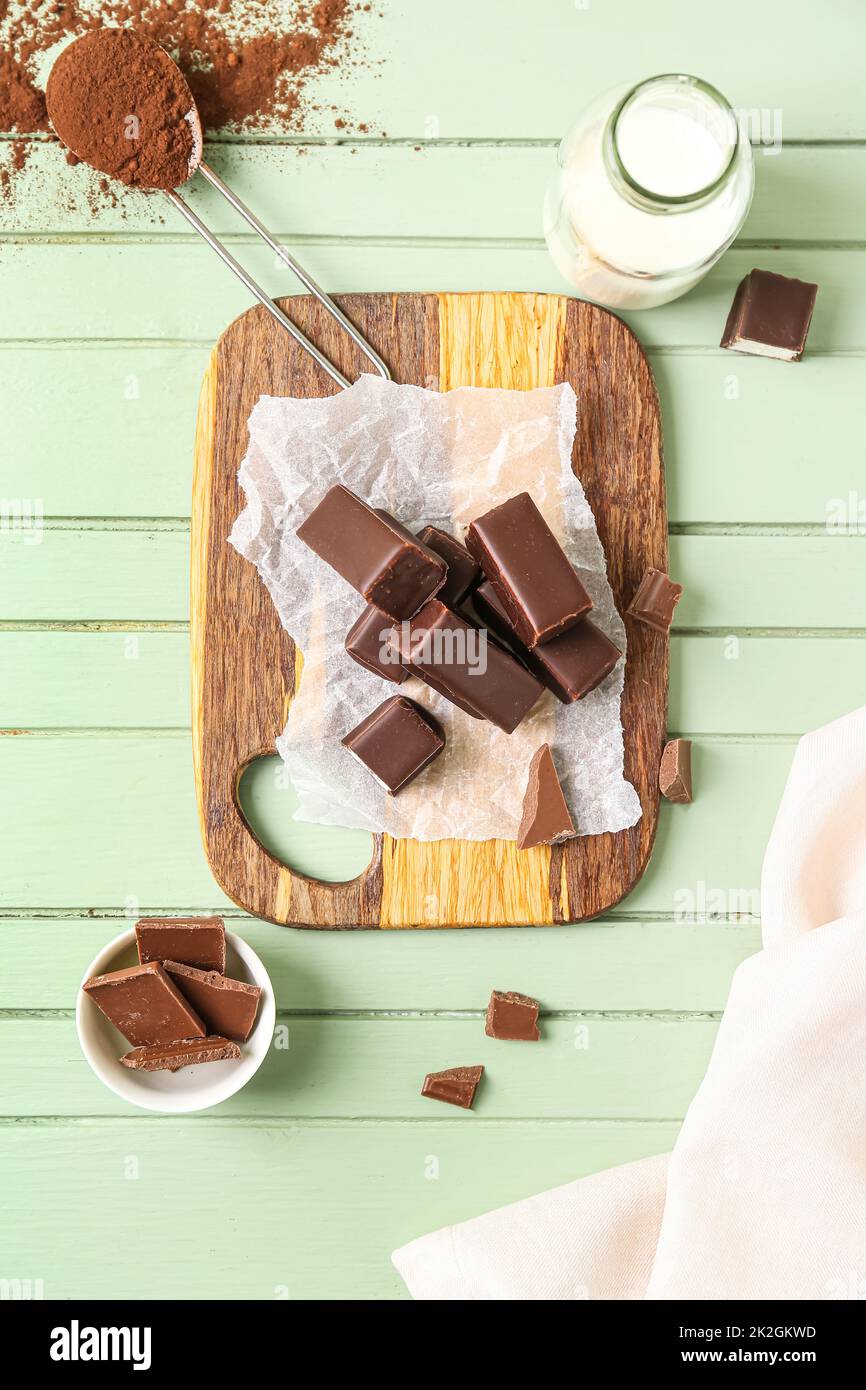 Board with tasty bird's milk candies and ingredients on color wooden ...