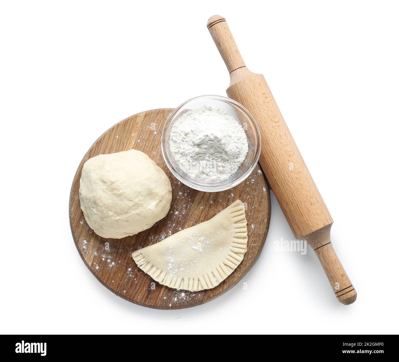 Board with dough, raw cheburek, bowl of flour and rolling pin on white ...