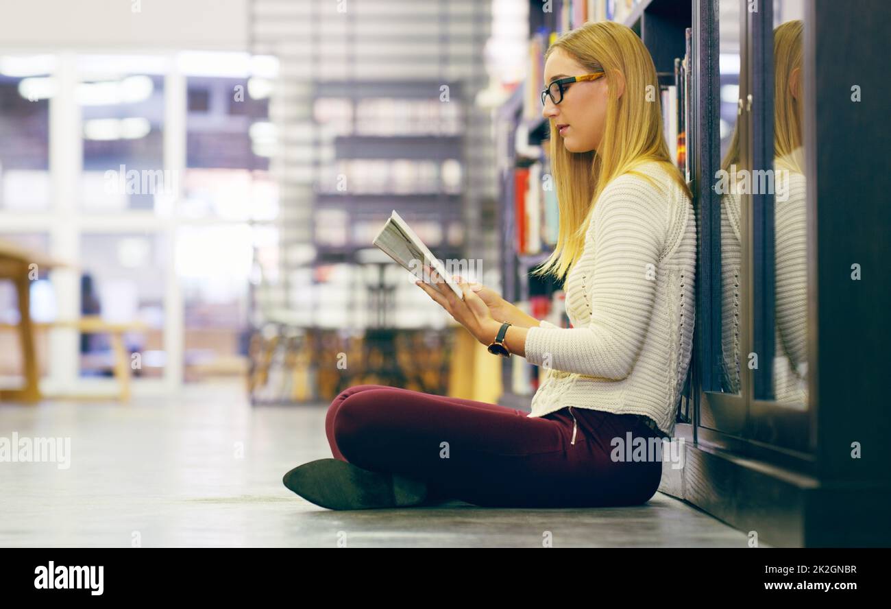 Catching up on her studies. Full length shot of an attractive young ...