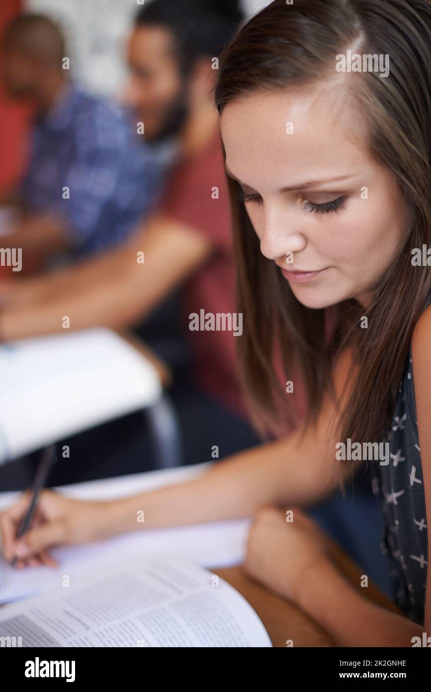 Checking her resouces. An attractive young varsity student sitting in a ...