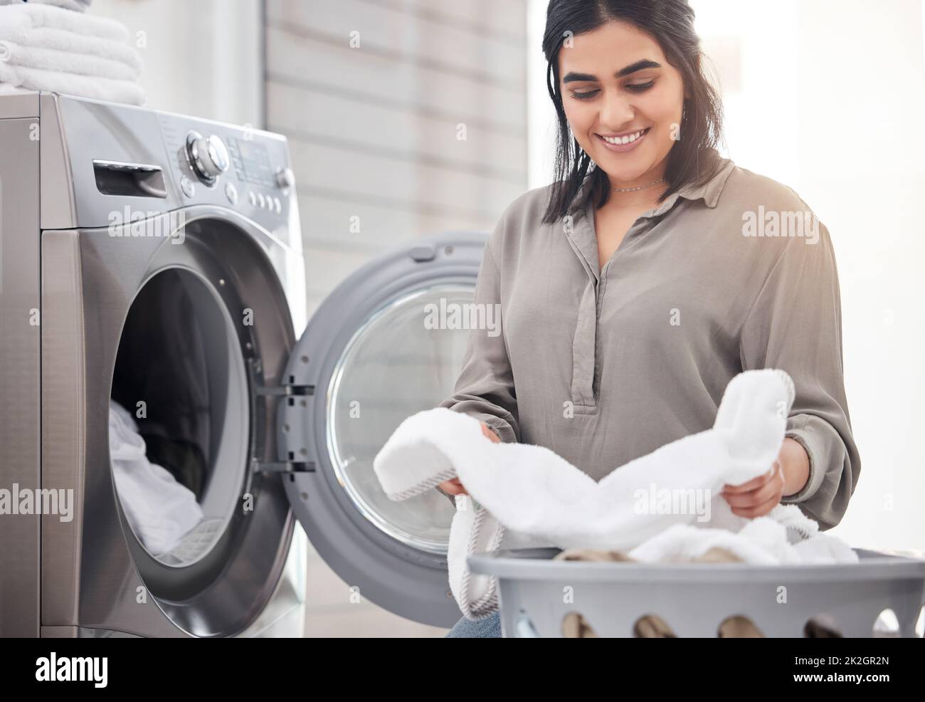 They look as good as new. Shot of a young woman doing laundry at home Stock Photo - Alamy