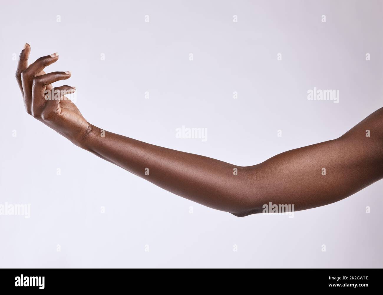 Im only human. Studio shot of a woman holding out her arm against a ...